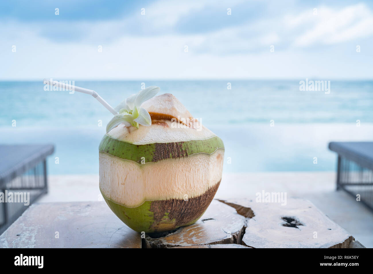 Tropical coconut drink in the shell, opened with straw and white ...