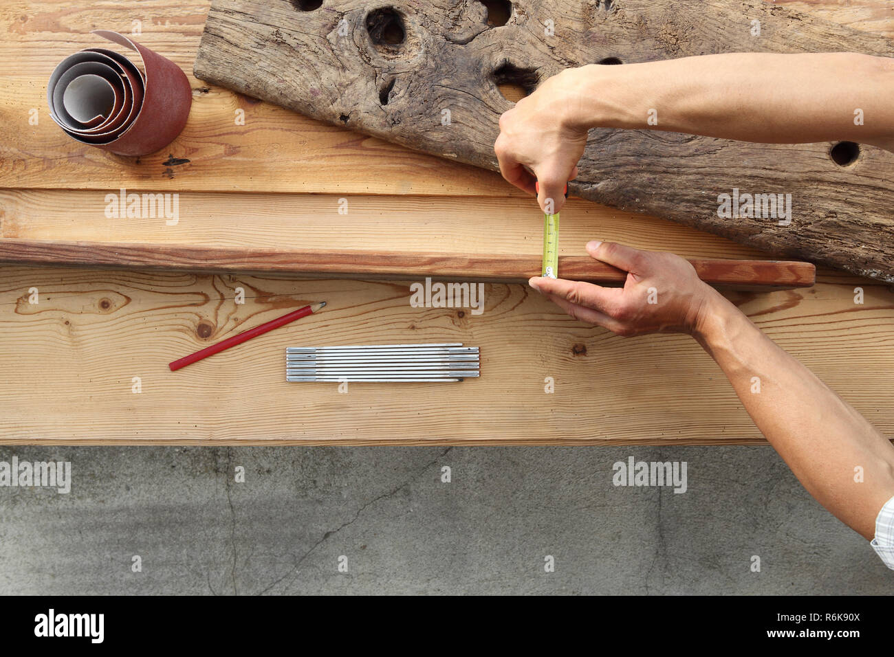 hands carpenter work the wood, measure with the meter the thickness of ...