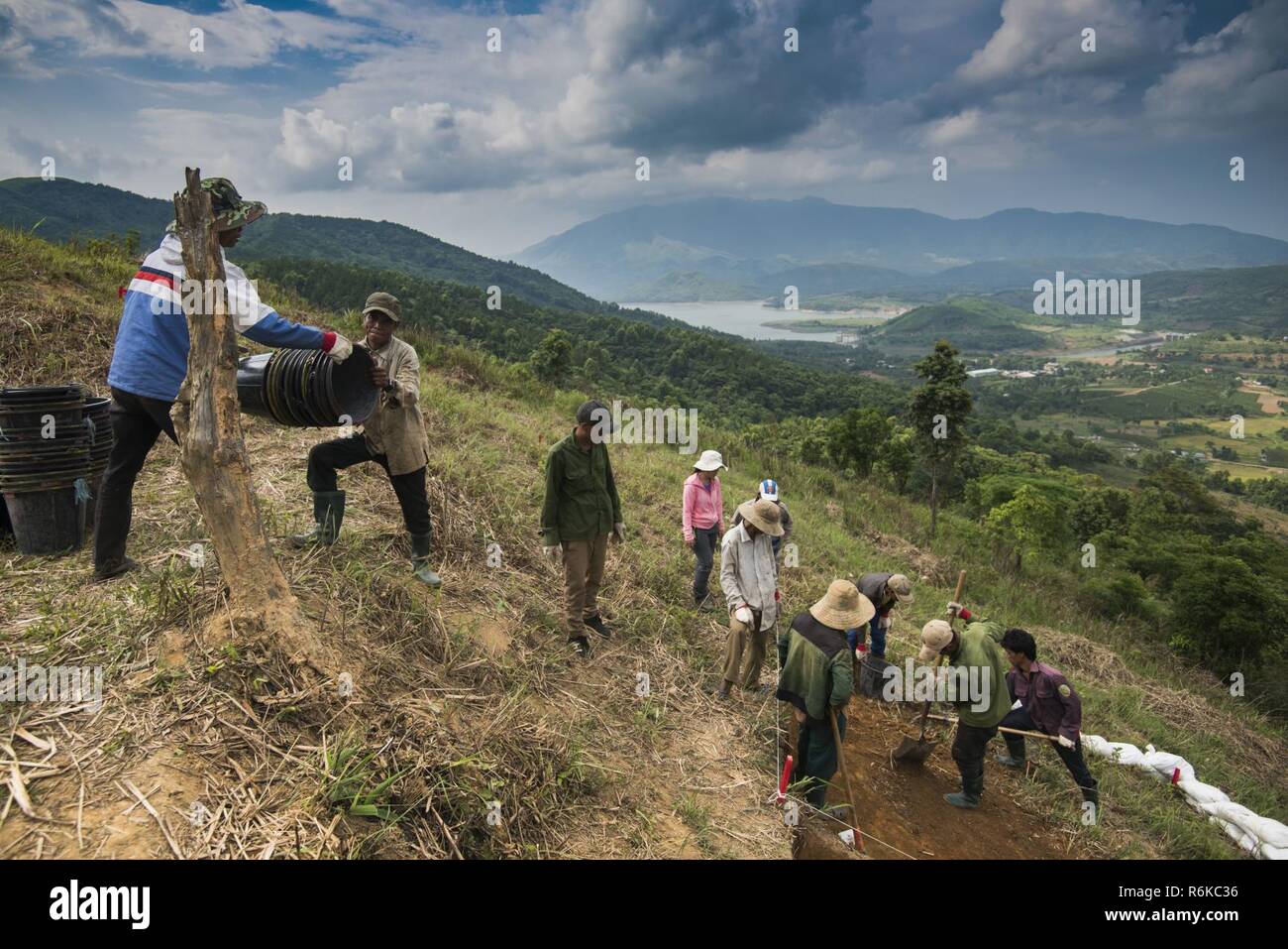 Local Vietnamese villagers form a bucket line to aid the Defense POW ...