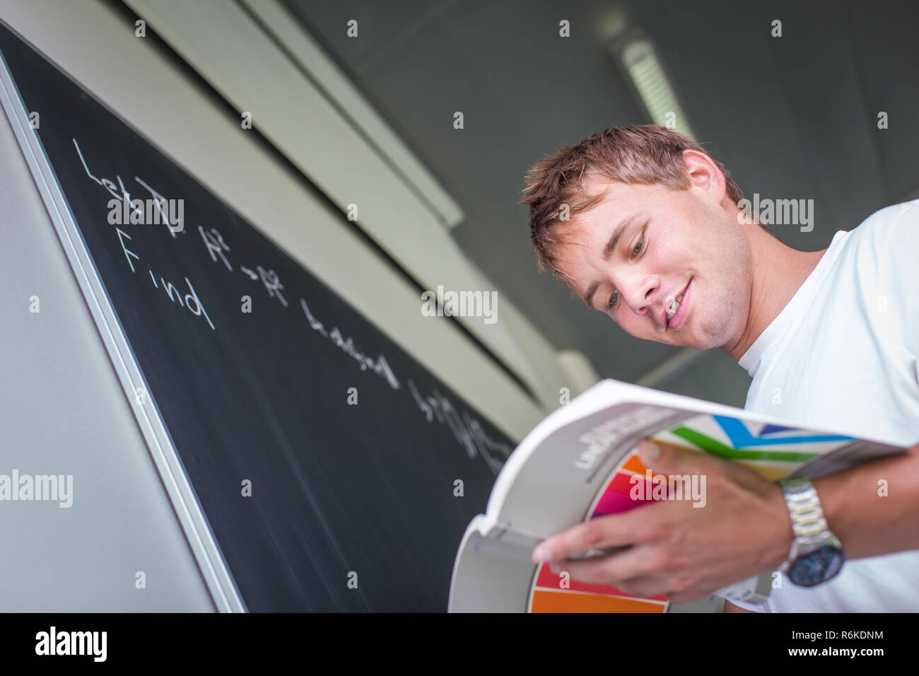 Handsome college student solving a math problem during math class in ...