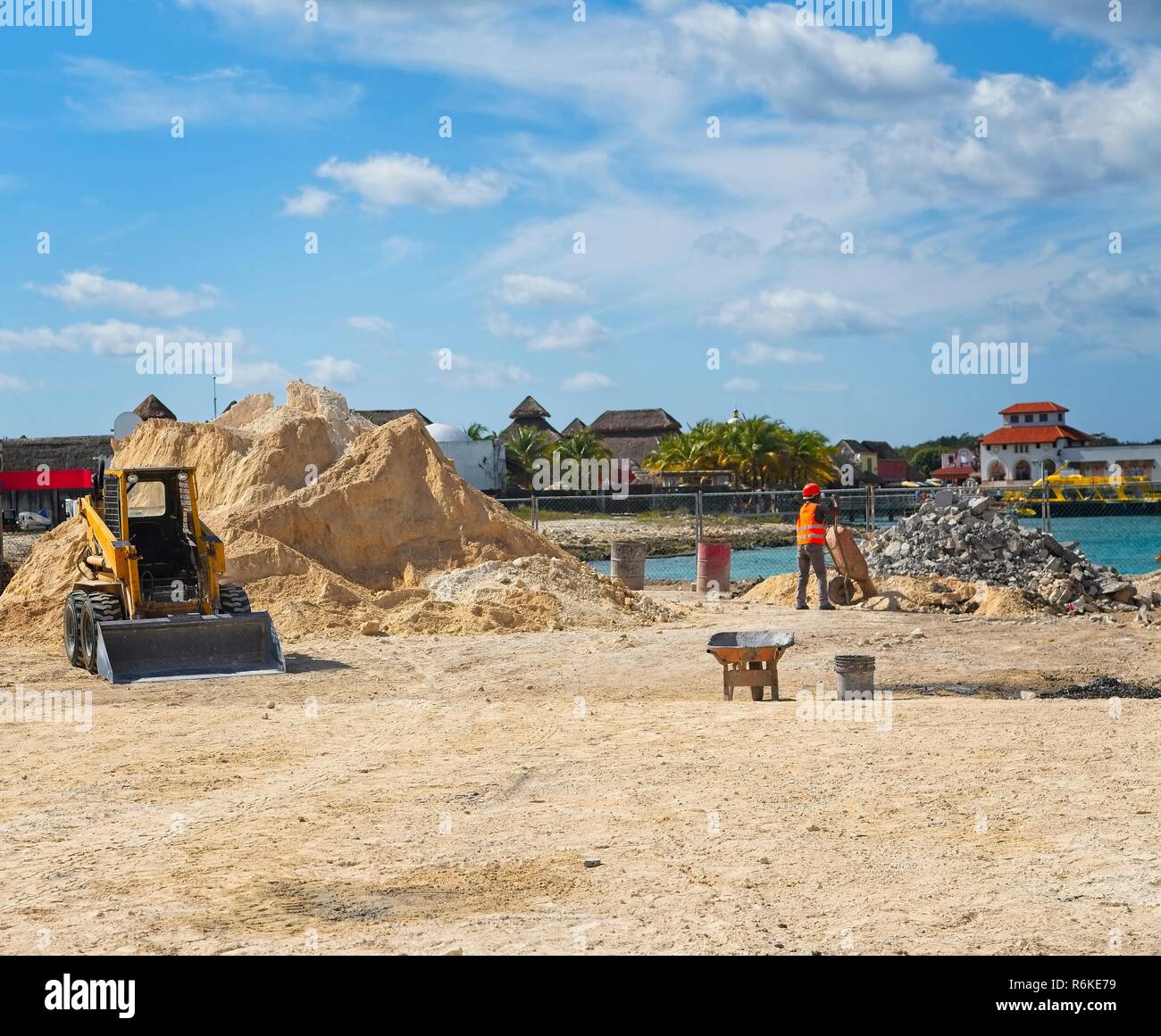 Sand Pile in Coastal Construction with a bulldozer and workers Stock ...
