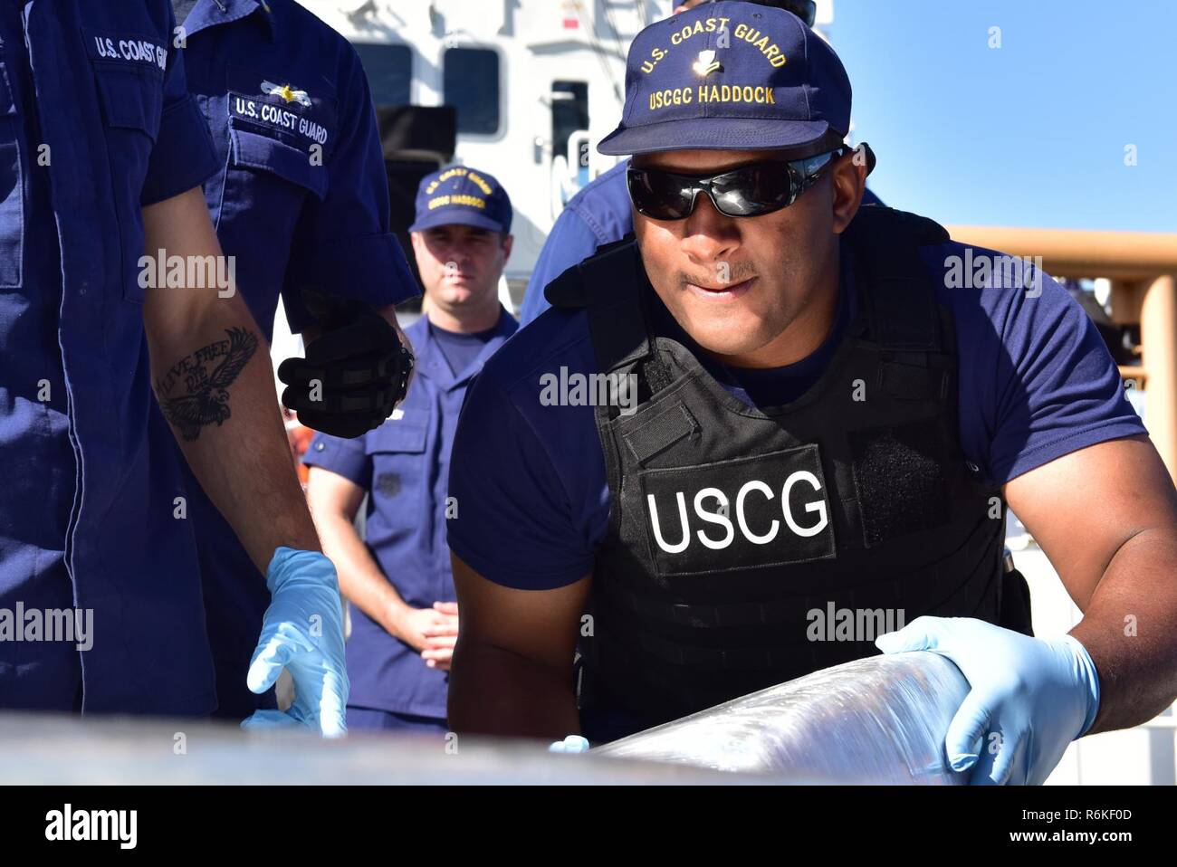 The crew of the U.S. Coast Guard Cutter Haddock offloads approximately ...