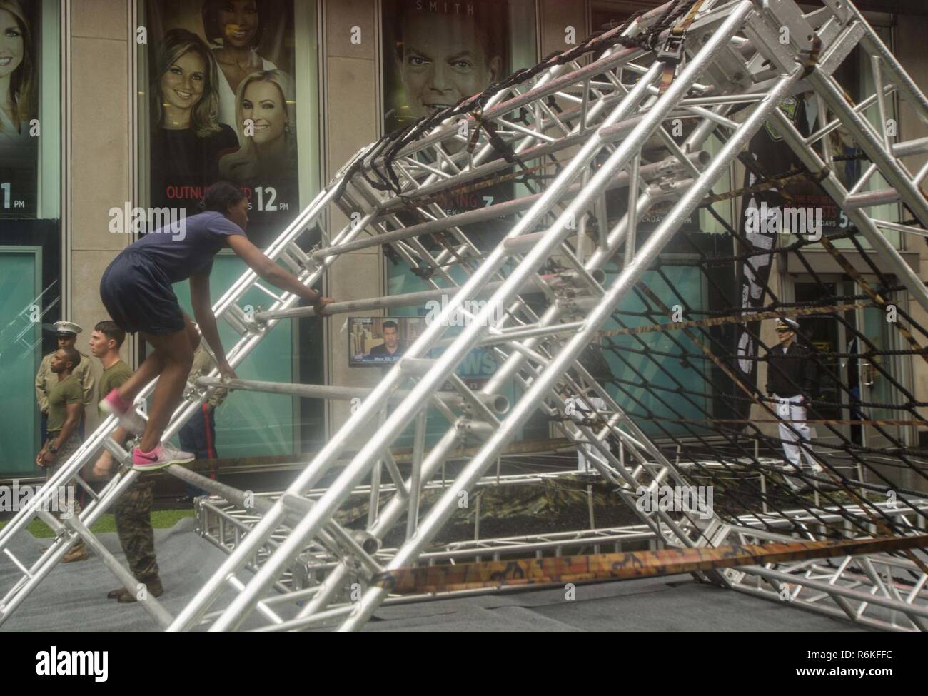 A Coast Guardsman climbs a ladder wall during a Fox & Friends obstacle ...