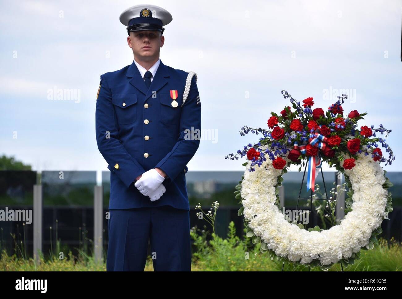 A member of the Coast Guard Ceremonial Honor Guard stands by a wreath ...
