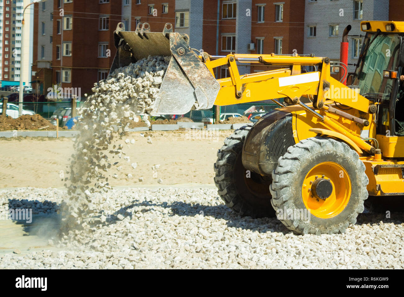 Excavator pours rubble from the bucket. Construction of the playground ...