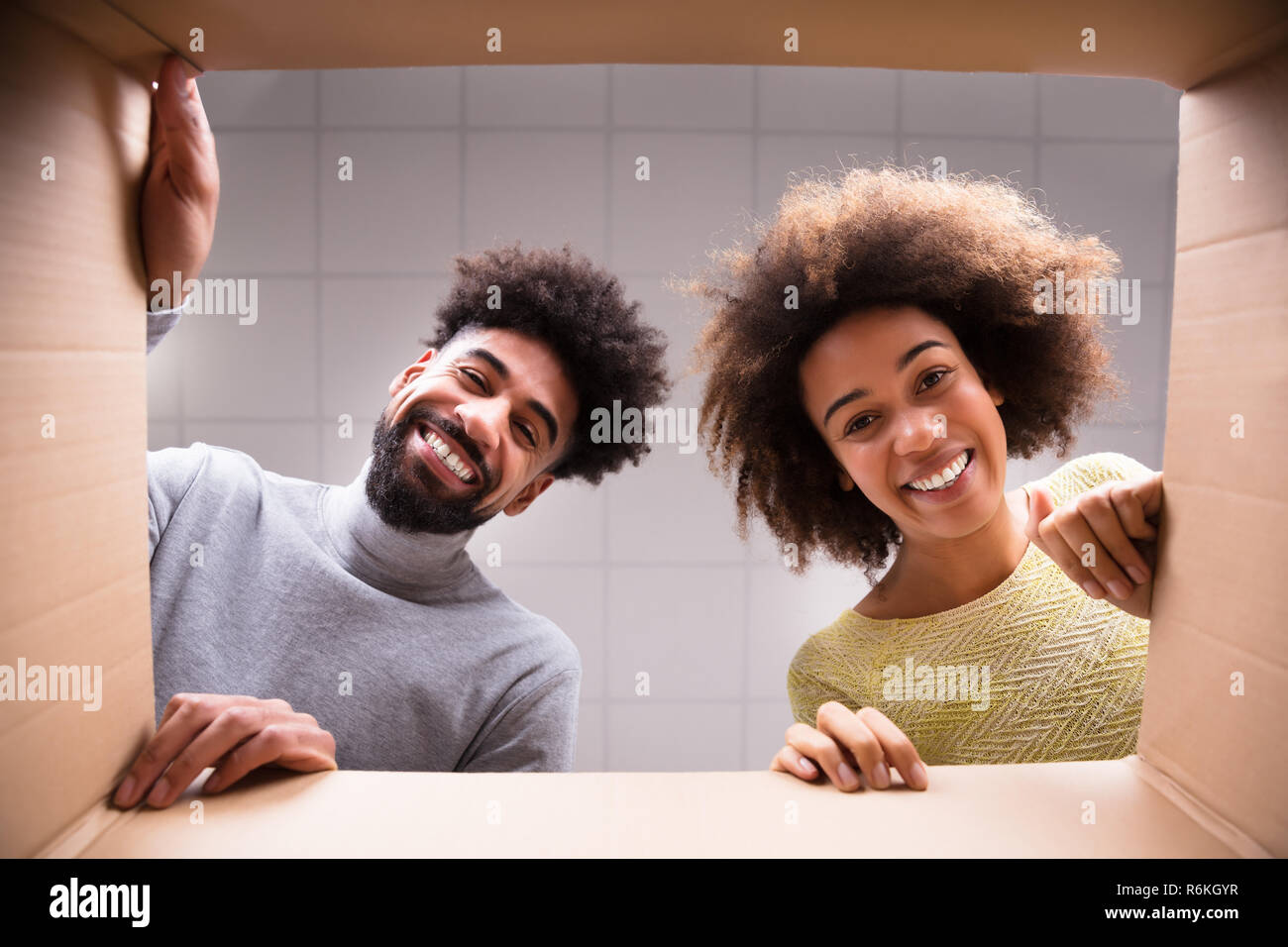 Happy Couple Looking Inside Cardboard Box Stock Photo - Alamy