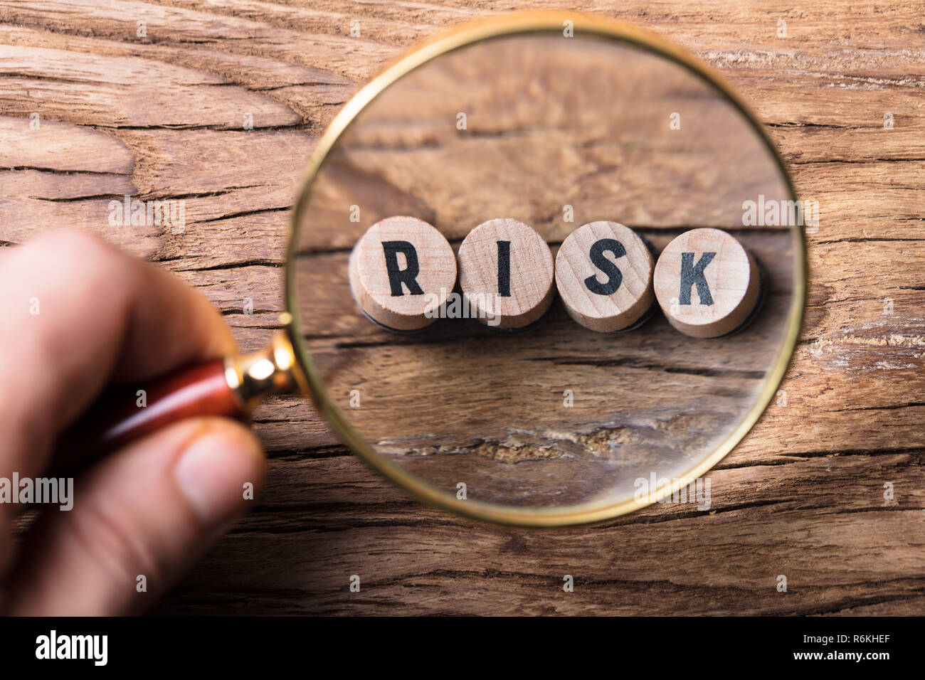 Person Looking At Risk Blocks Through Magnifying Glass Stock Photo - Alamy