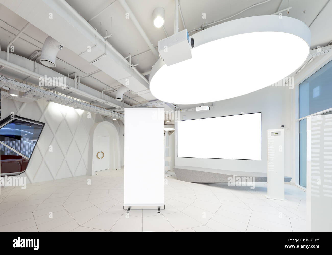 Blank roll up banner stand and info display in office lobby interior ...