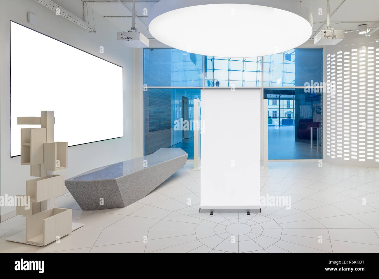 Blank roll up banner stand and info display in office lobby interior ...
