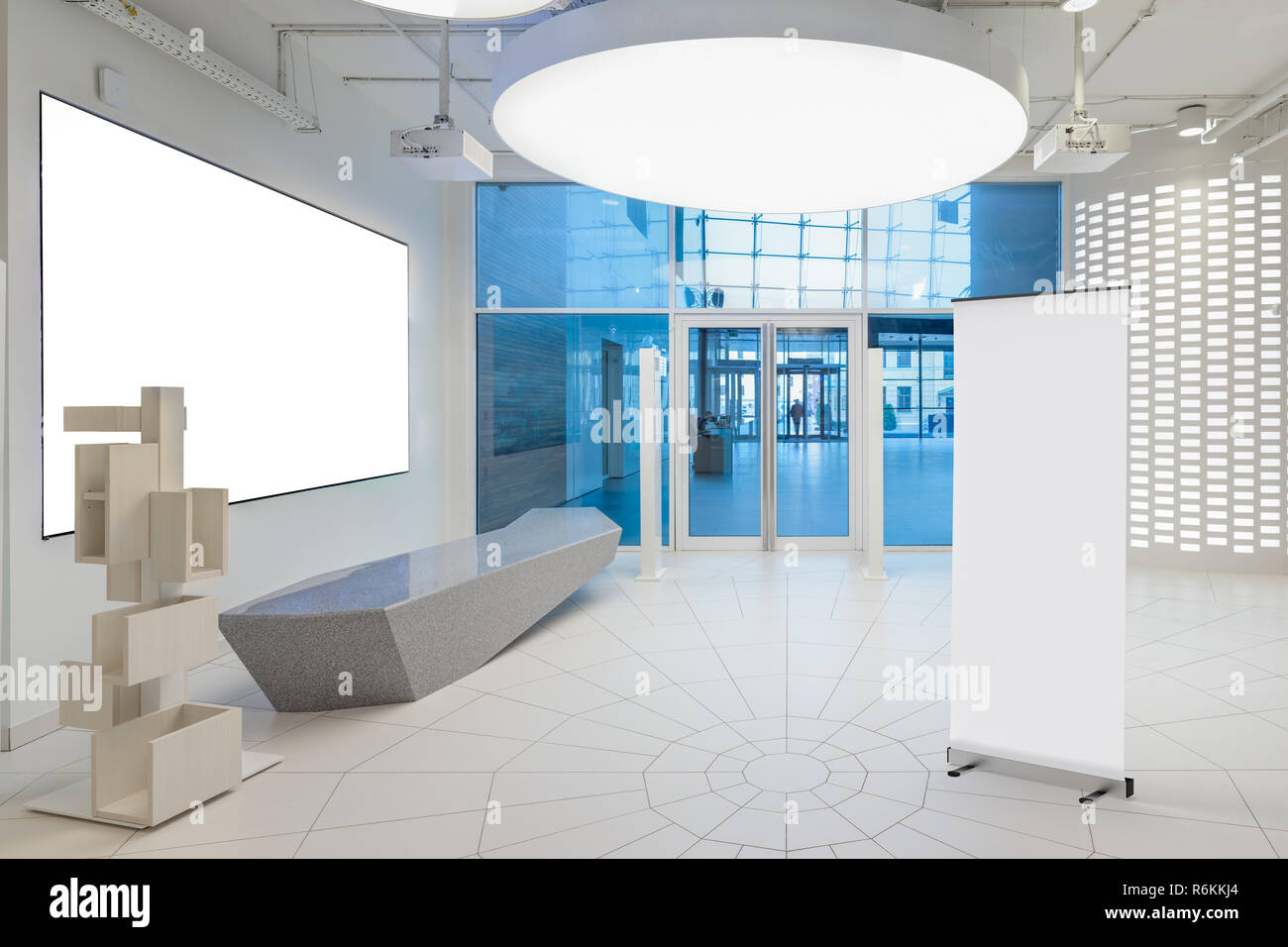 Blank roll up banner stand and info display in office lobby interior ...