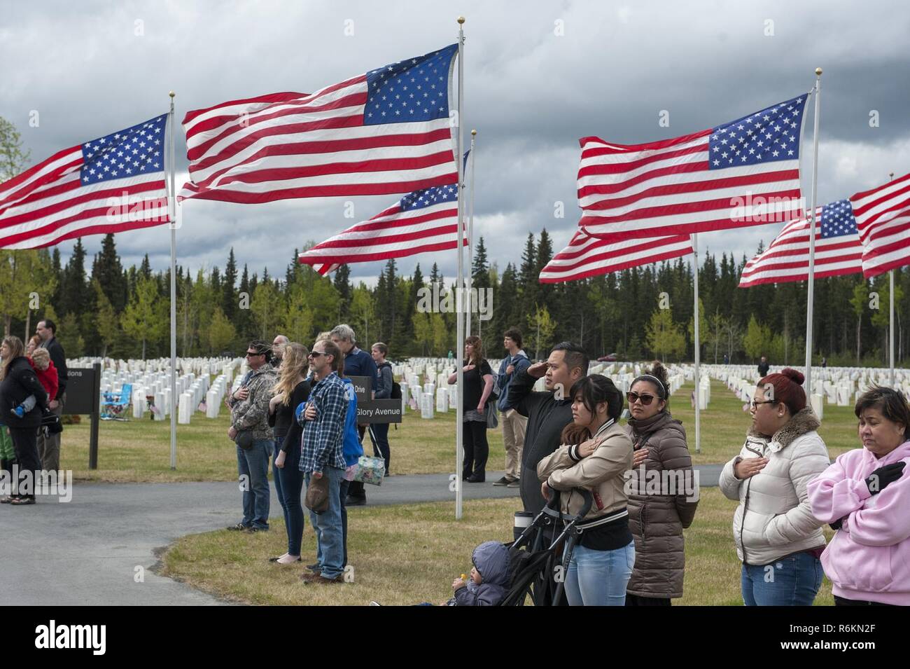 Attendees salute or put their hand over their heart during a Veteran ...