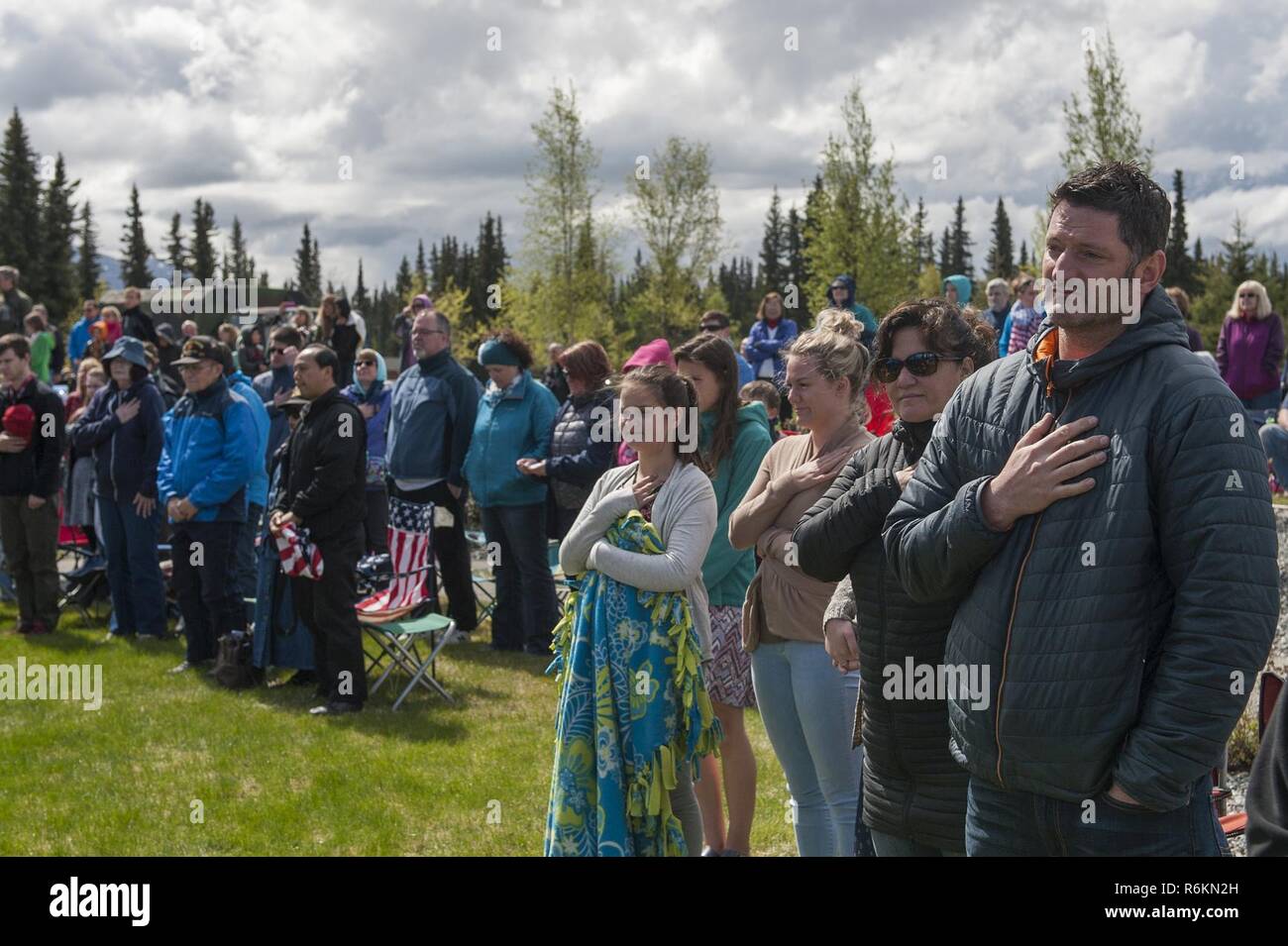 Attendees salute or put their hand over their heart during a Veteran ...