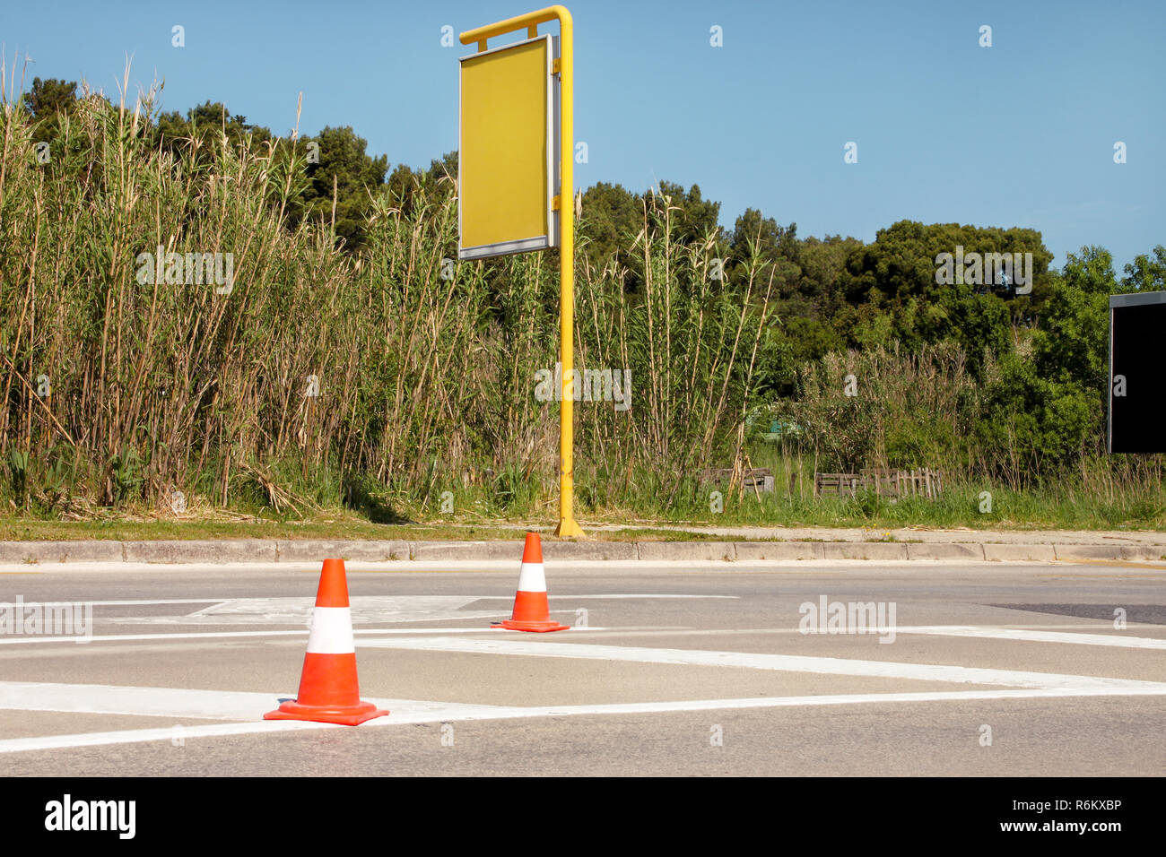 Work on road. Construction cones with yellow advert board at street ...