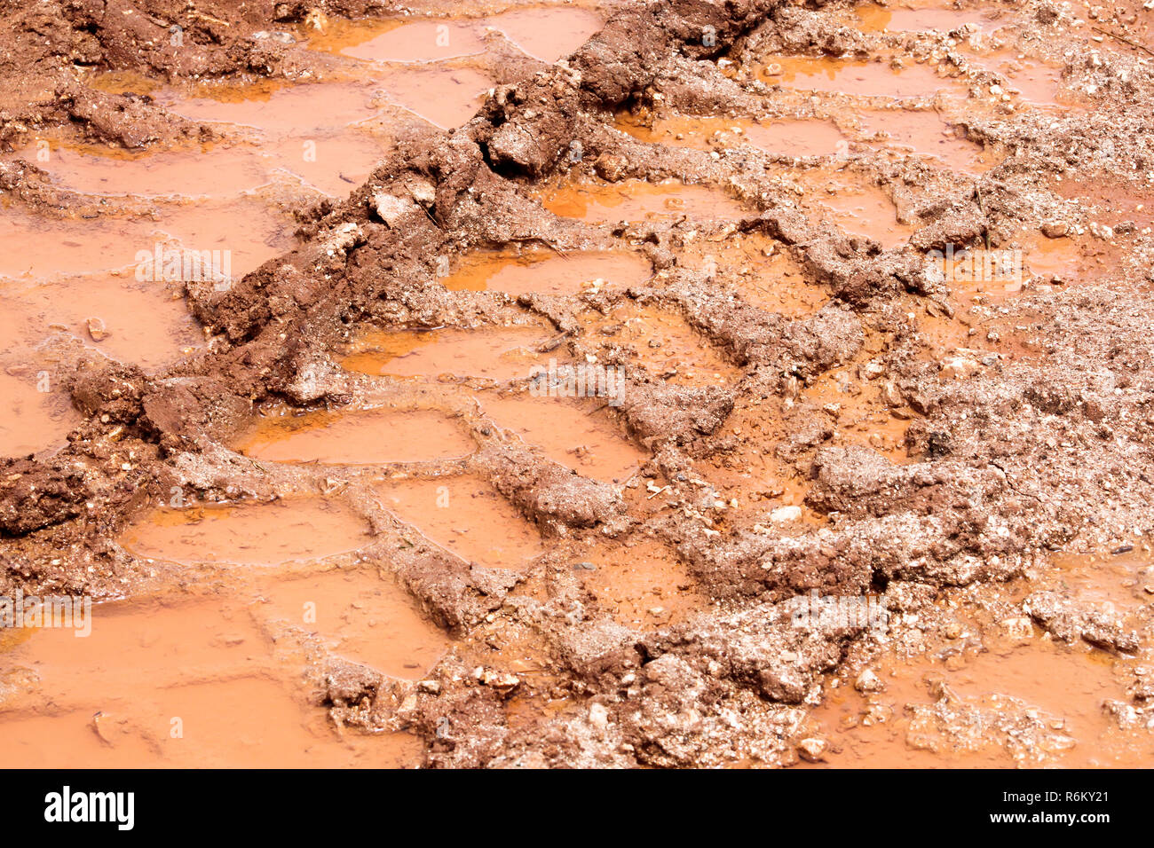 Wheel trace on road, puddle and mud after rain. Traces on soil of ...