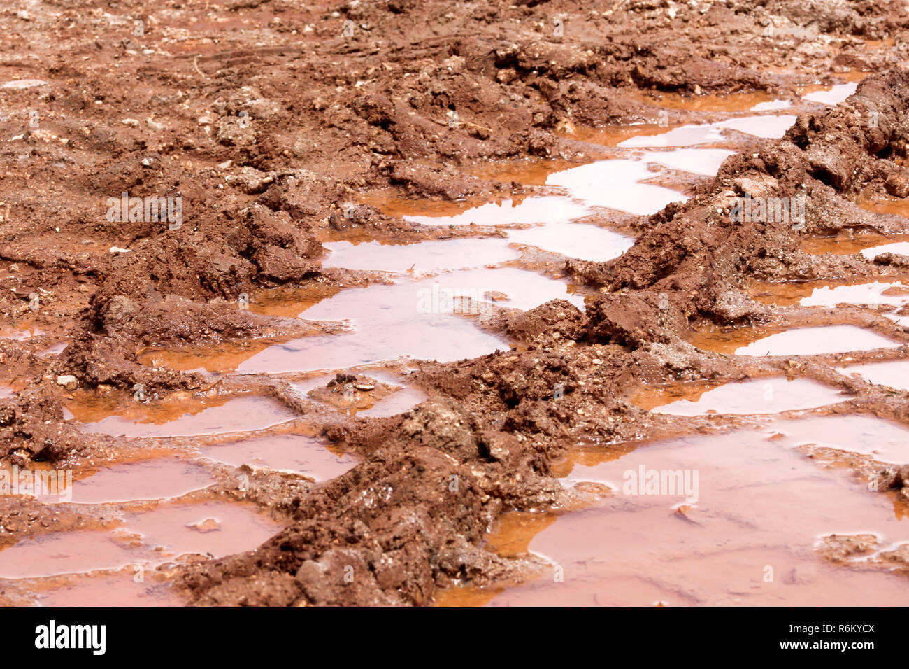 Wheel trace on road, puddle and mud after rain. Traces on soil of ...