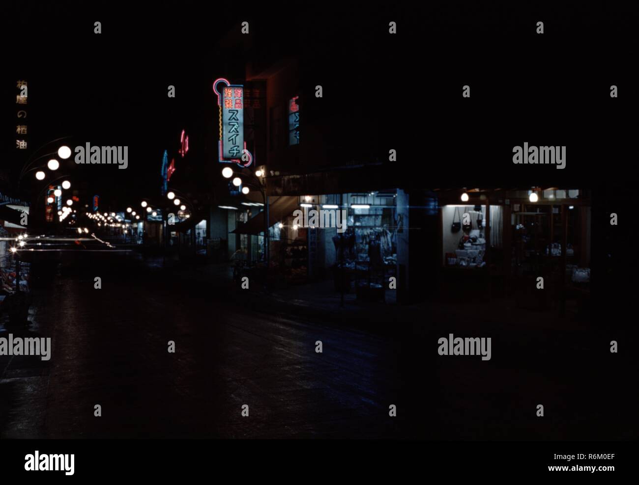 Night view with neon signs, street lighting, and store windows on an ...