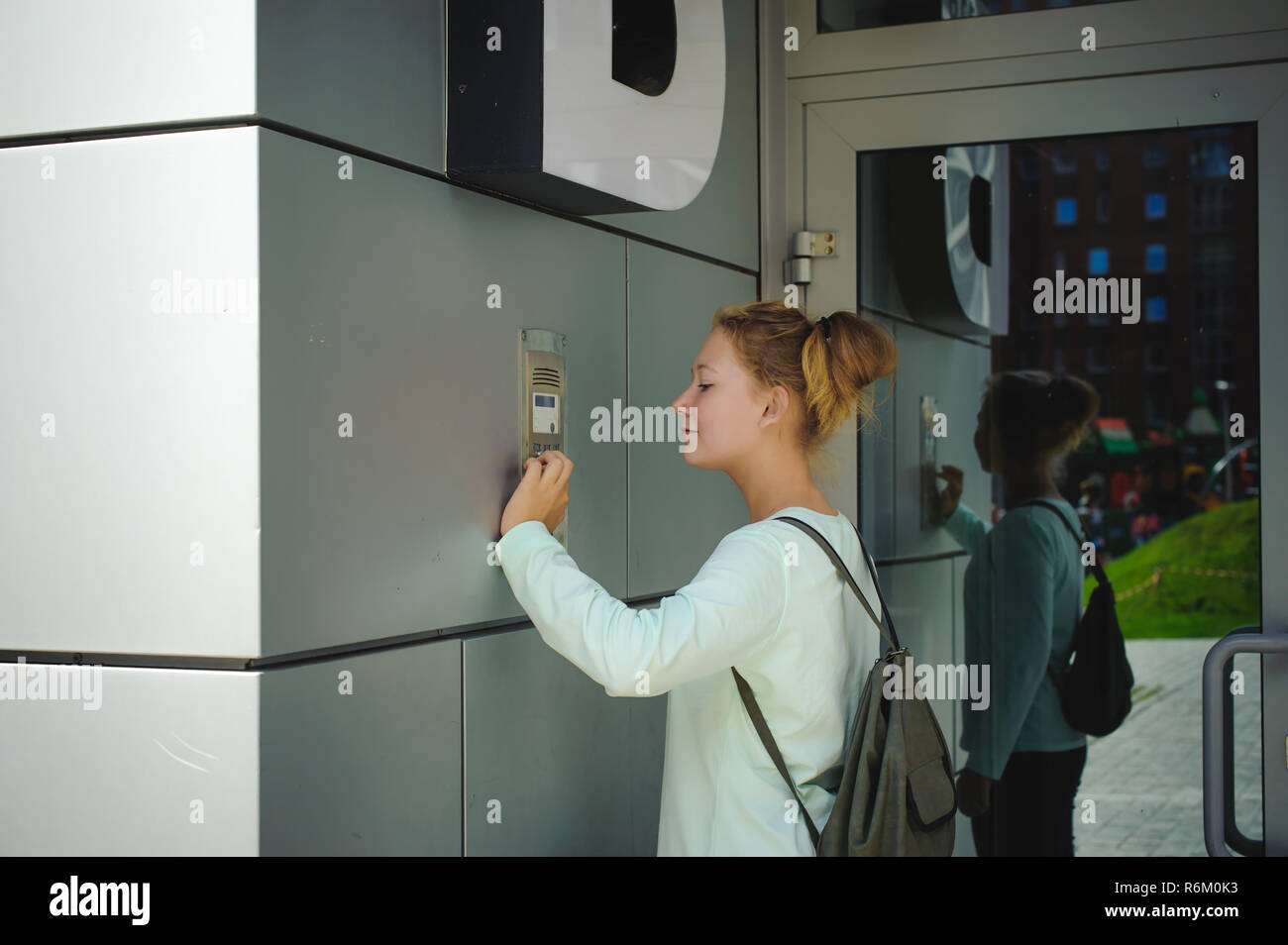 young blond teenager schoolgirl dials the code for a call over the ...