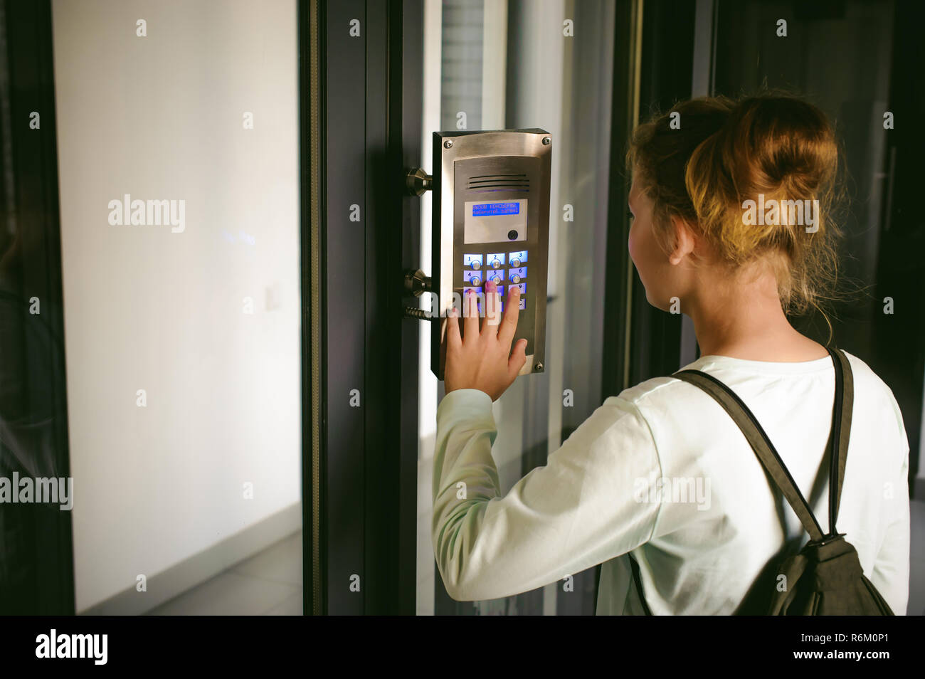 young blond teenager schoolgirl dials the code for a call over the ...