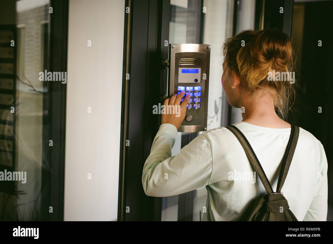 young blond teenager schoolgirl dials the code for a call over the ...