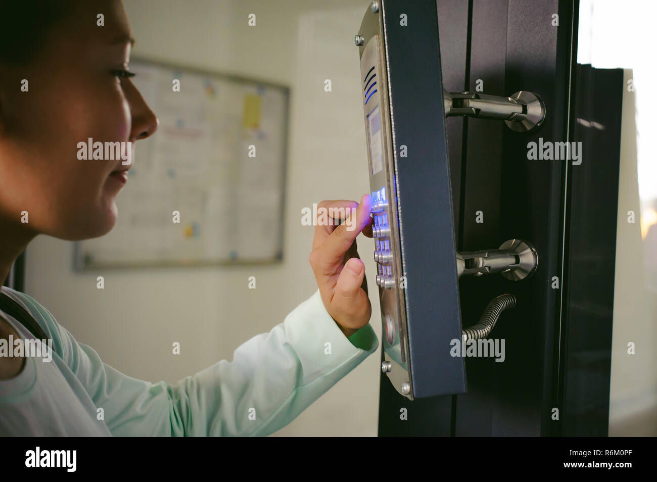 young blond teenager schoolgirl dials the code for a call over the ...