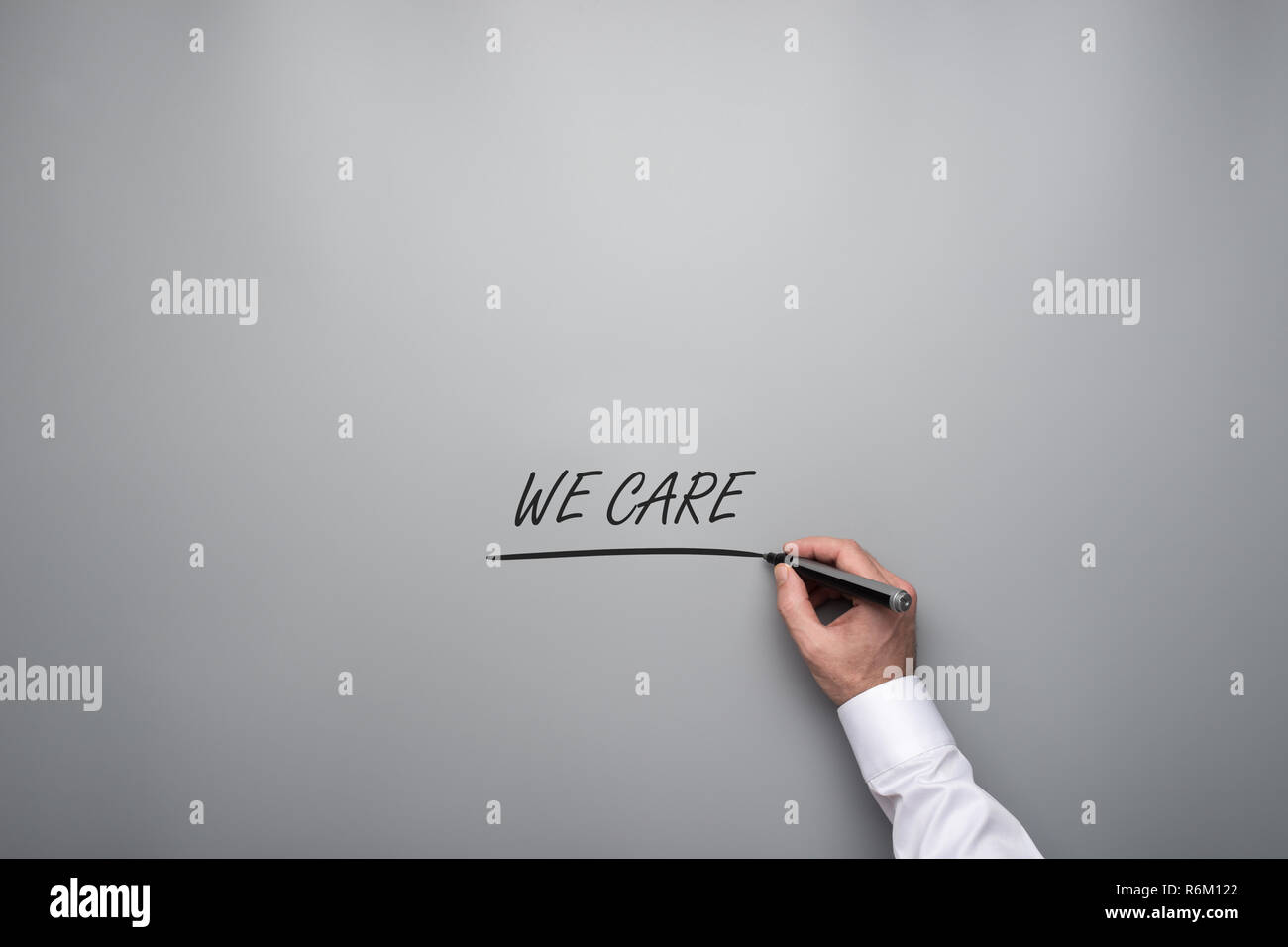 Male hand underlining a we care sign with black marker written over ...
