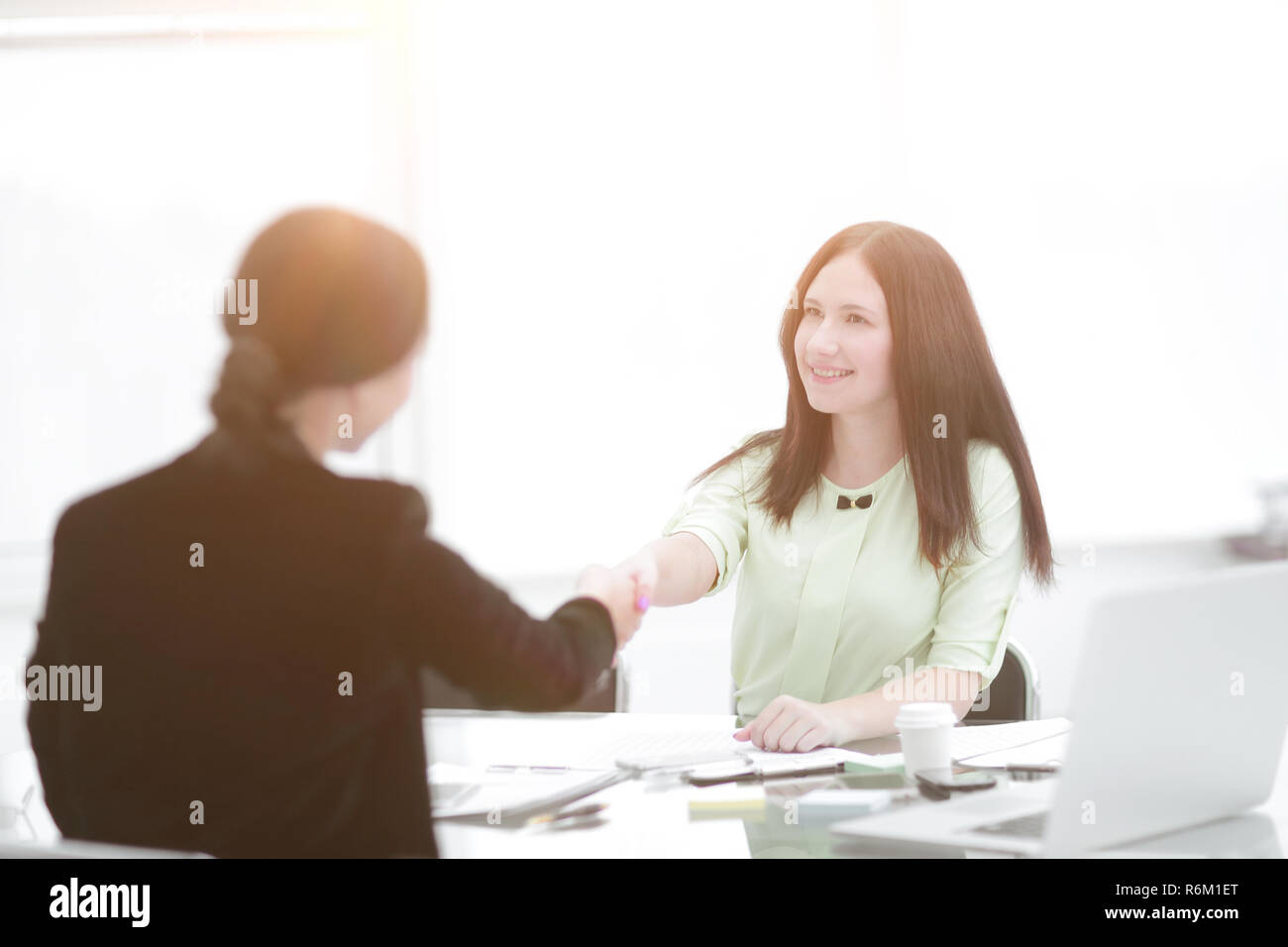 welcome handshake of two business women at the Desk.photo with copy ...