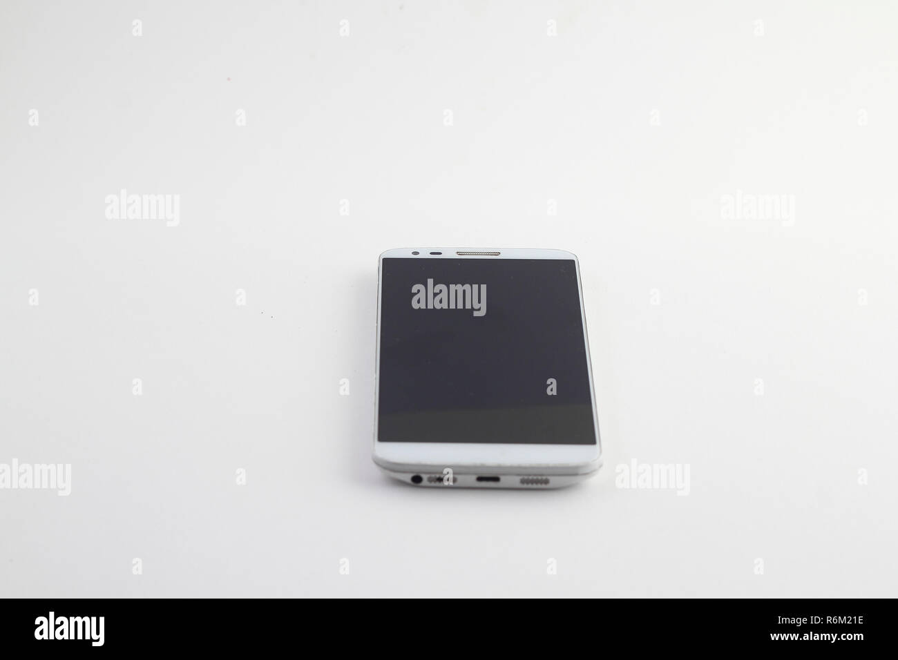 White mobile phone isolated on white background. Phone on the table ...
