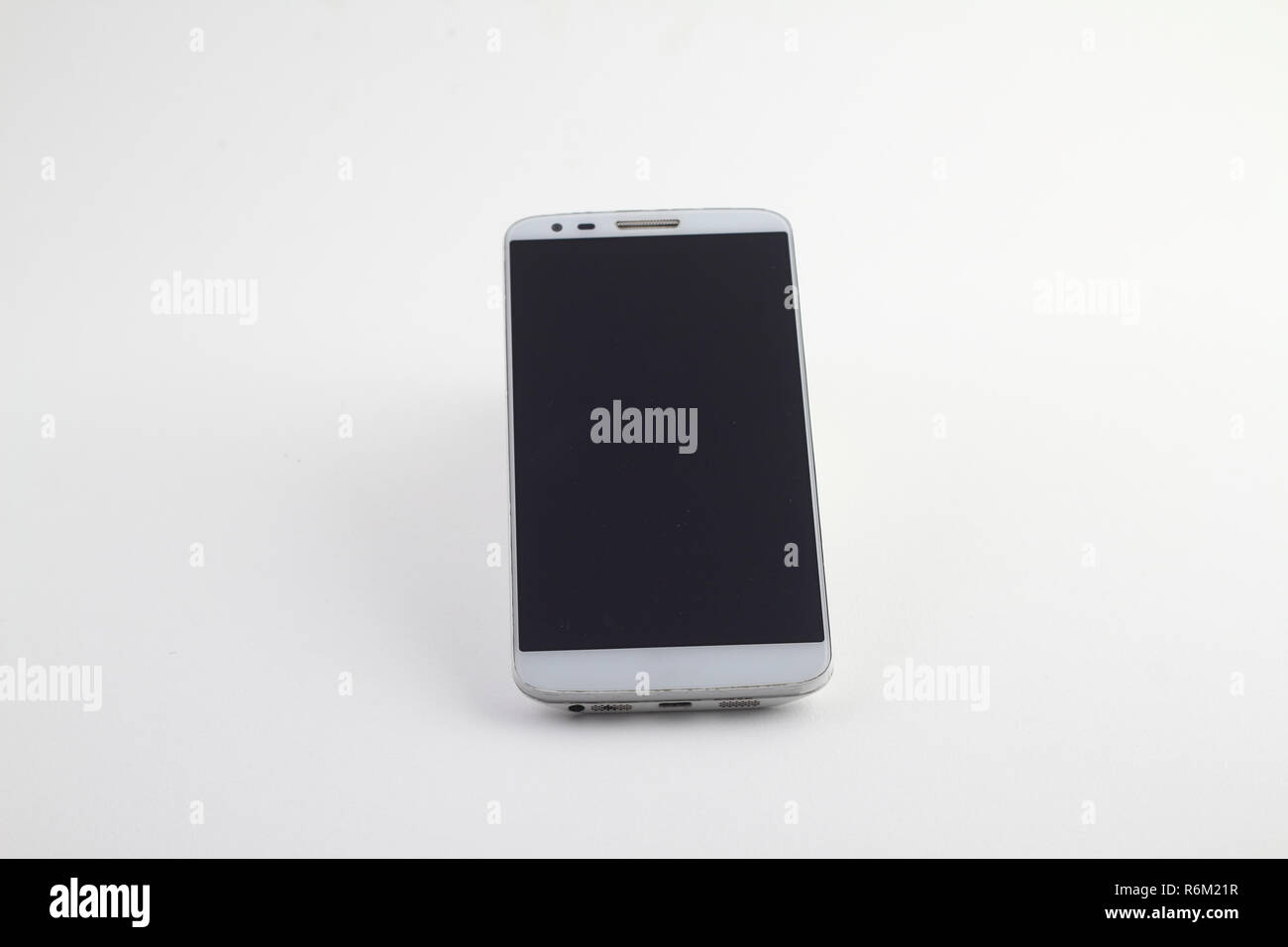 White mobile phone isolated on white background. Phone on the table ...