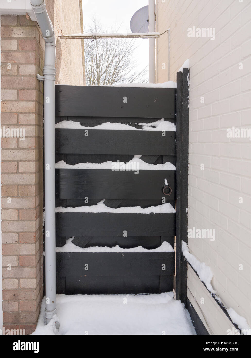 closed black gate with metal bolt with snow Stock Photo - Alamy