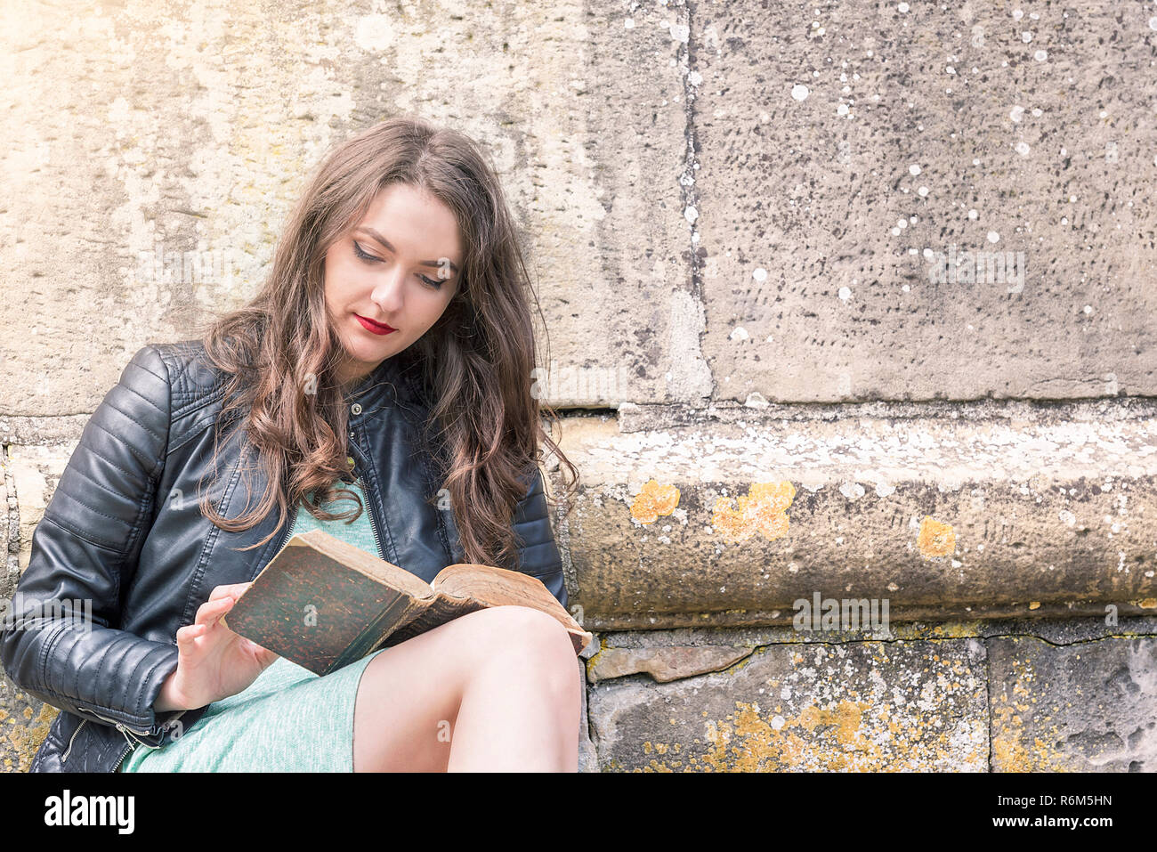Beautiful woman reading a book outdoor Stock Photo - Alamy