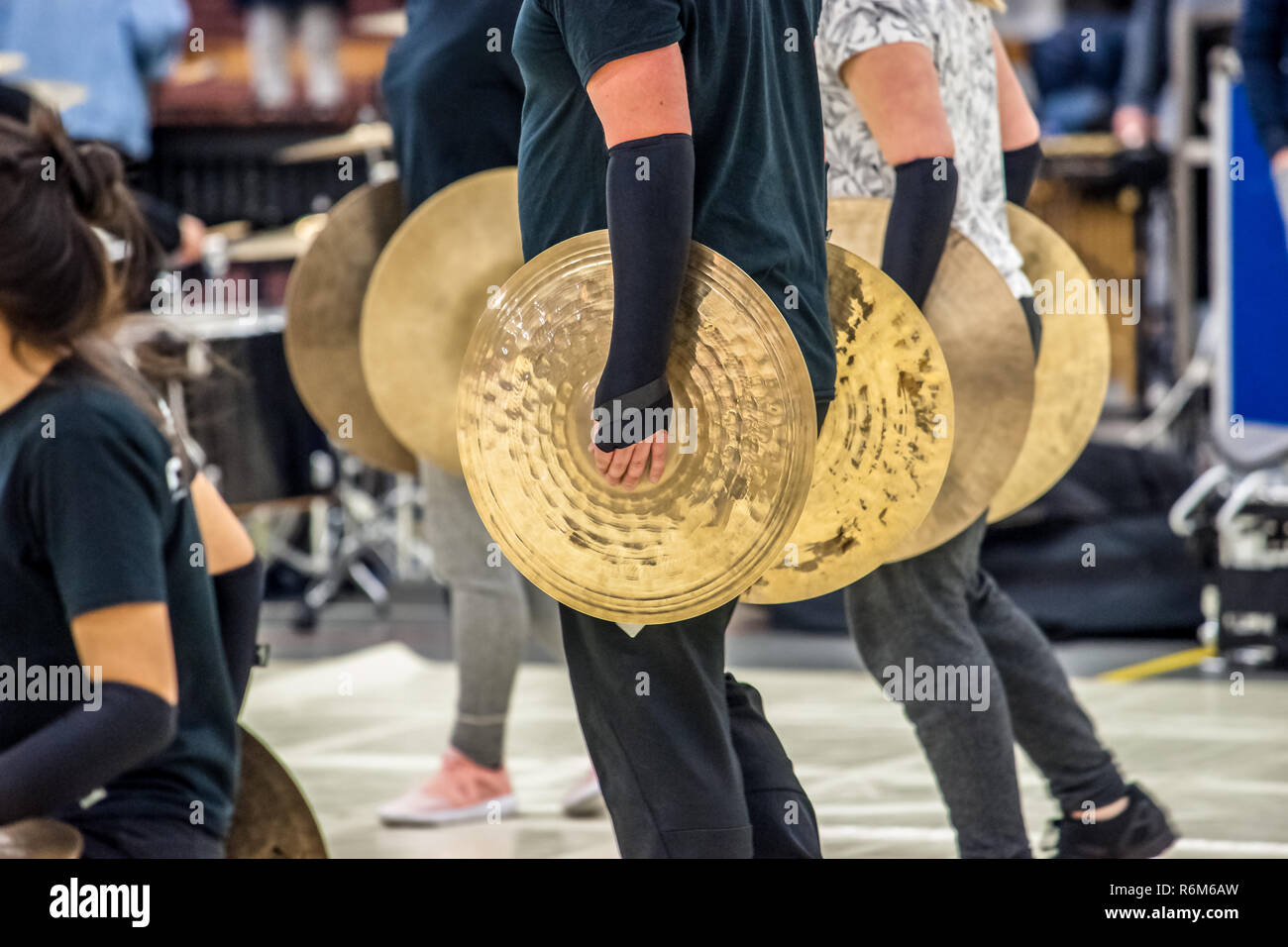 Musicians march, play and make music with shiny golden cymbals during a ...