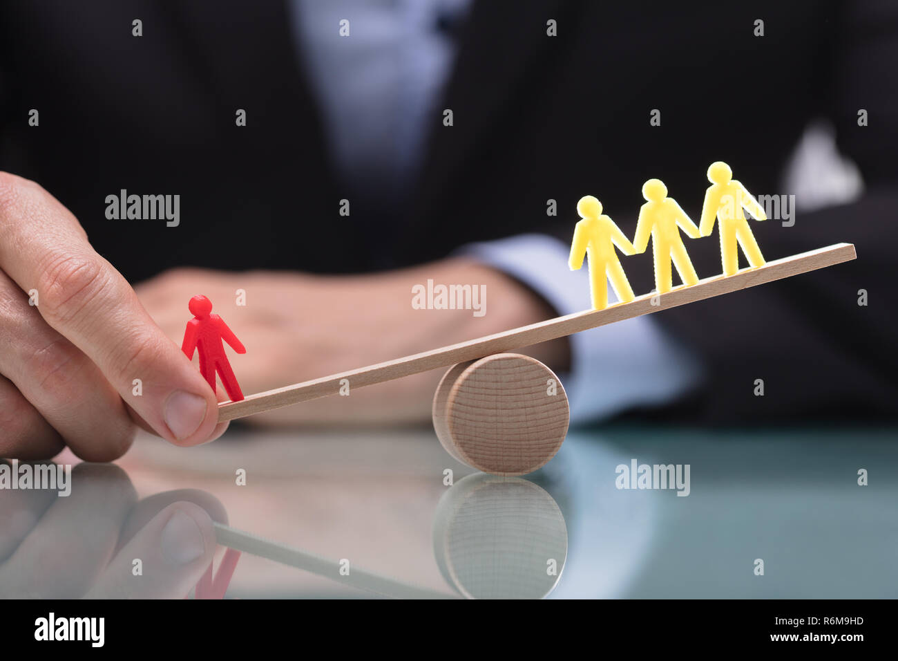 Businessperson Showing Imbalance Between Figures On Seesaw Stock Photo ...