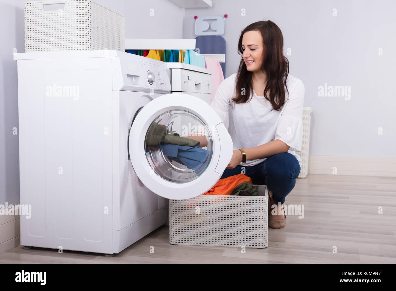 Woman Loading Clothes In Washing Machine Stock Photo - Alamy