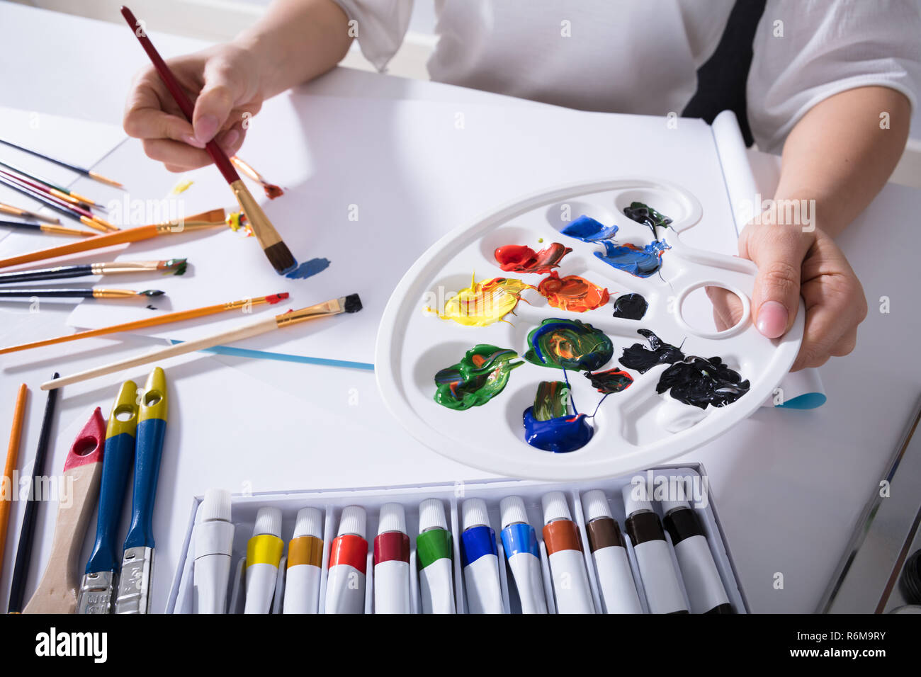Artist Holding Paint Palette While Painting On Canvas Paper Stock Photo ...