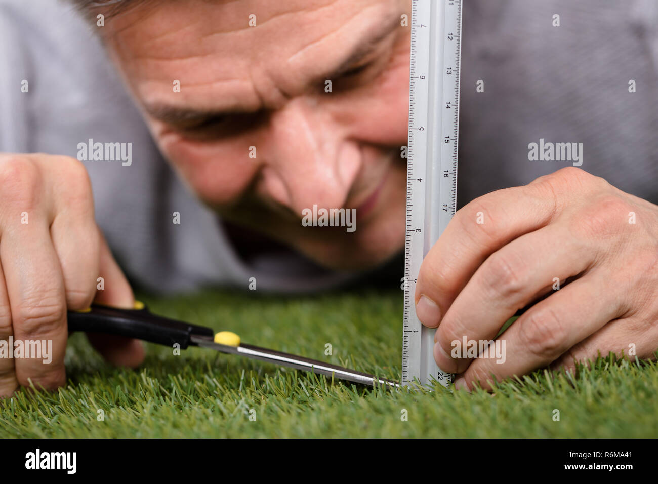 Man Using Measuring Scale While Cutting Grass Stock Photo - Alamy