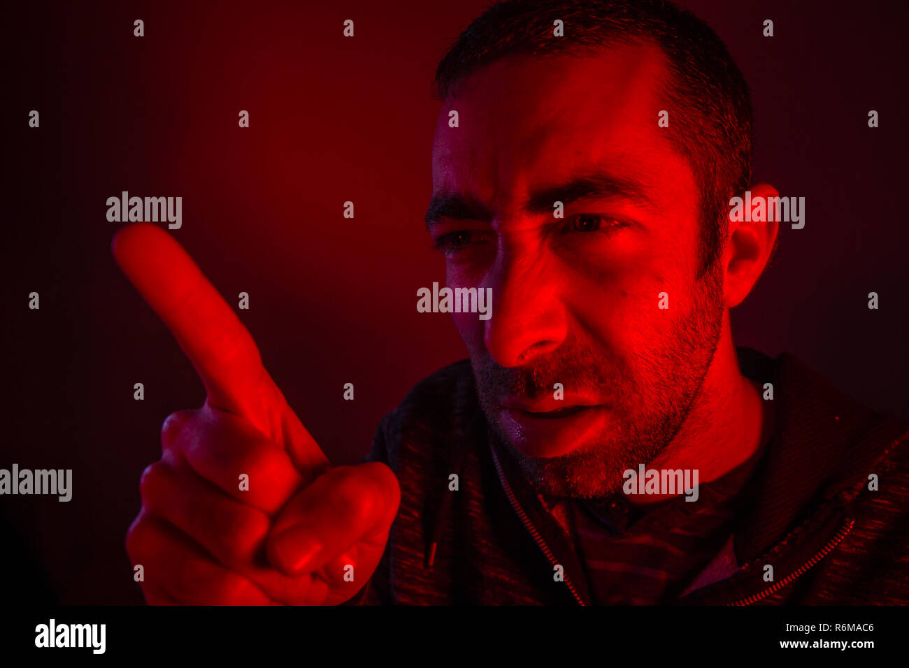 Close up portrait of a man with angry facial expression pointing his ...