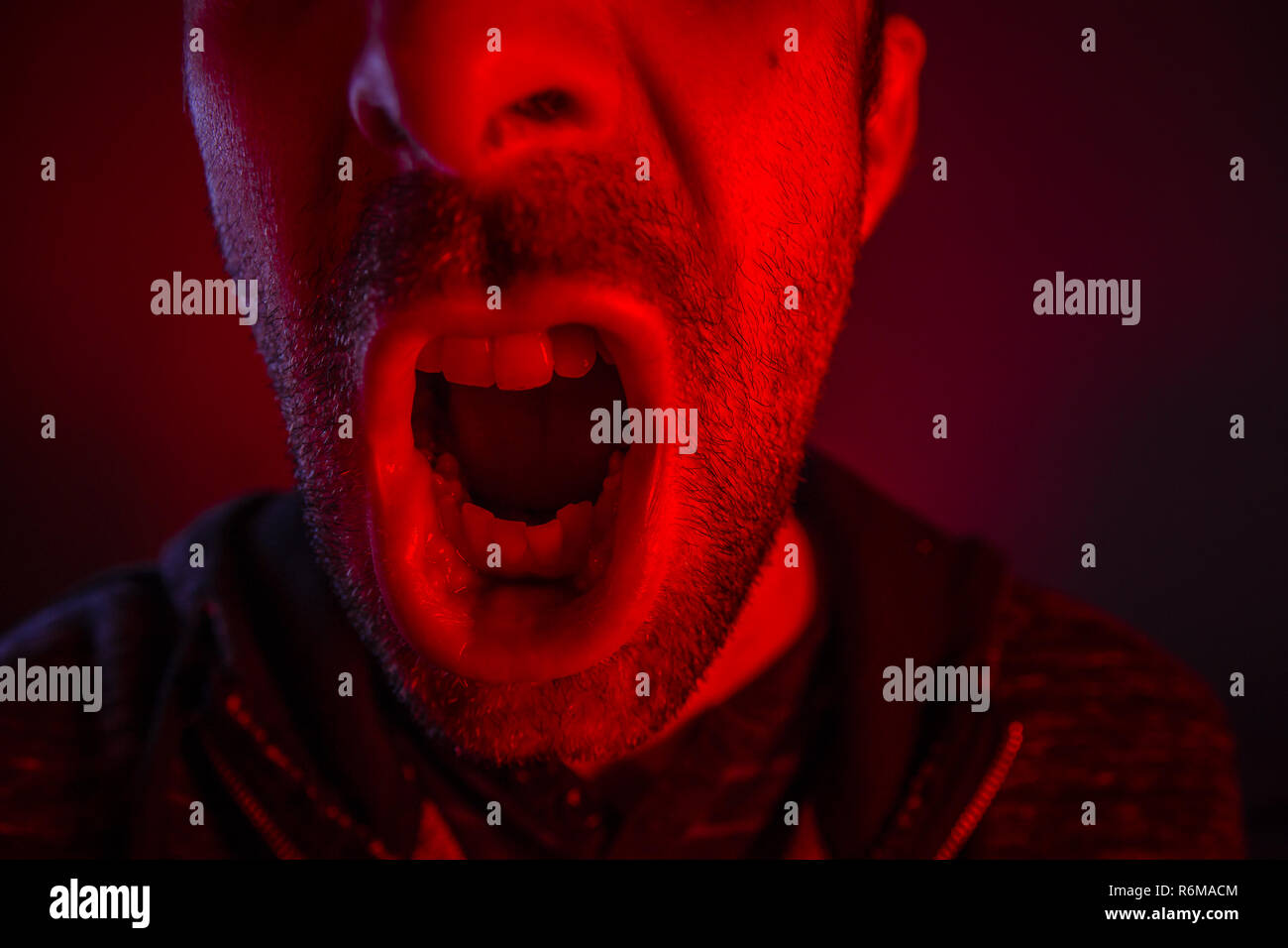 Man with angry facial expression screaming out loud Stock Photo - Alamy