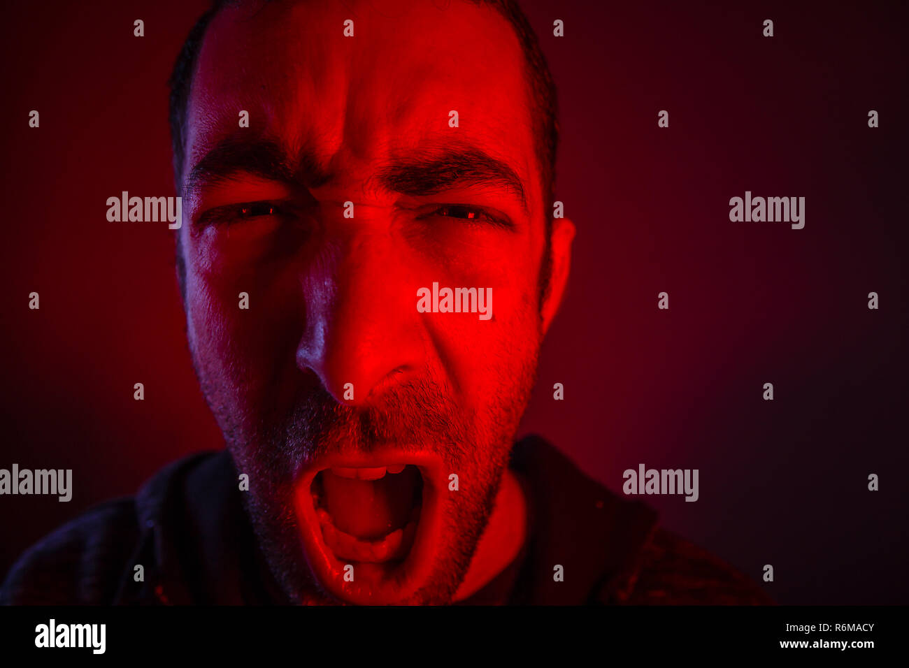 Man with angry facial expression screaming out loud Stock Photo - Alamy