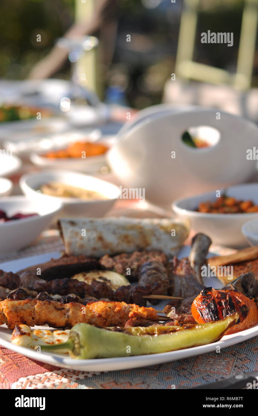 Traditional Cypriot meze and kebap barbecue party in the garden with ...