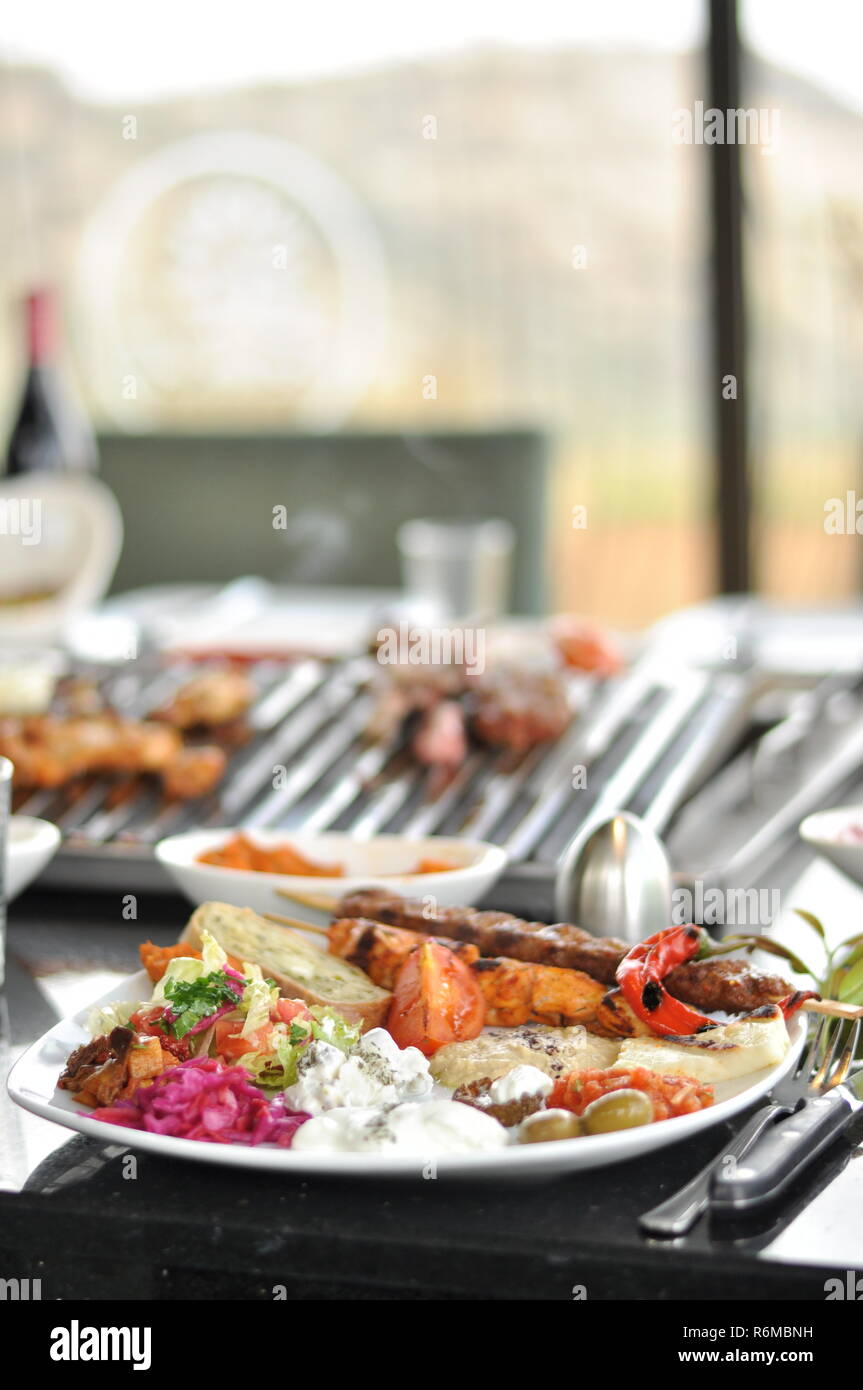 Traditional Cypriot meze and mix meat and chicken kebab table with ...