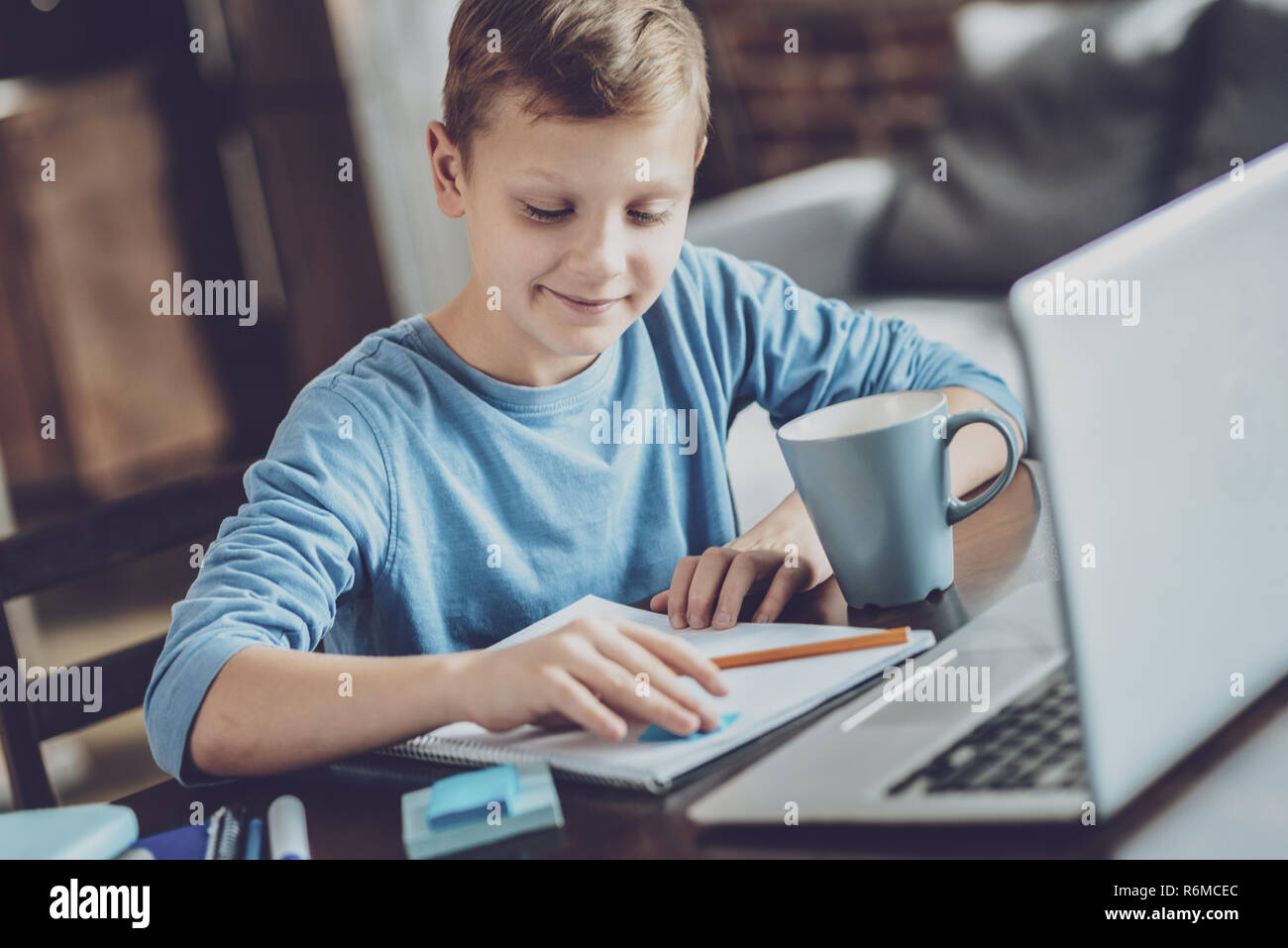 Cheerful boy completing home tasks Stock Photo - Alamy