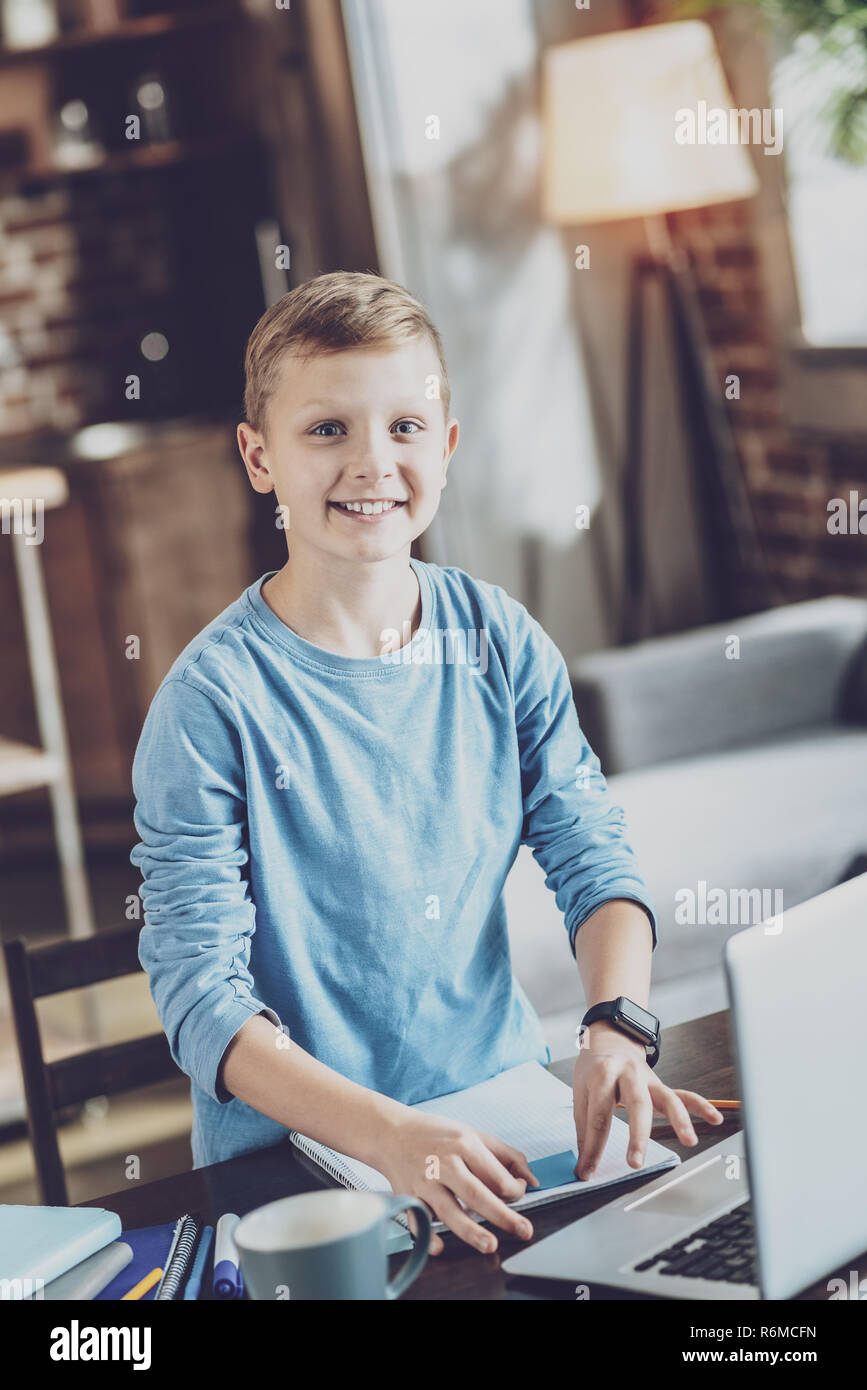 Joyful blonde kid putting sticker on paper sheet Stock Photo - Alamy
