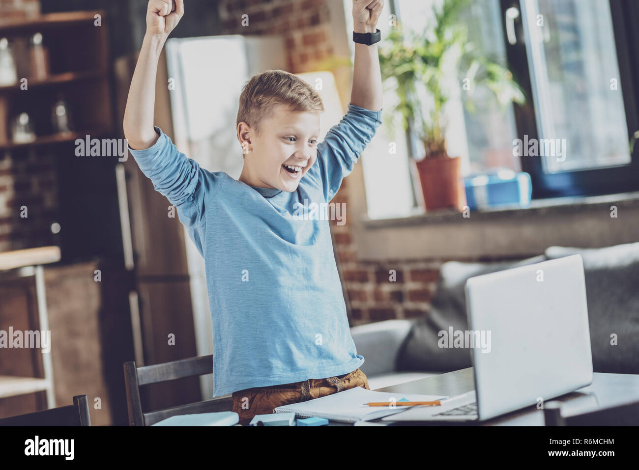 Happy blonde boy celebrating his success Stock Photo - Alamy