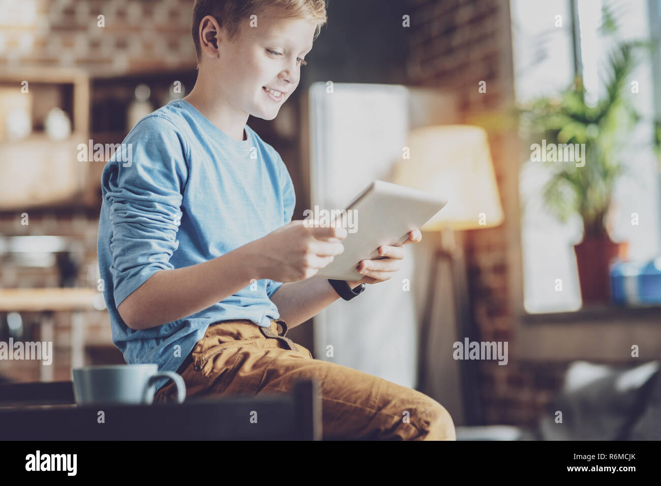 Pleased boy watching video lesson Stock Photo - Alamy