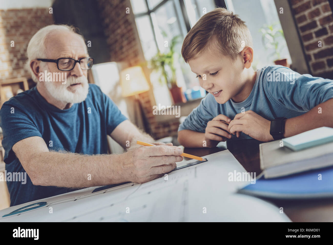 Concentrated mature man drawing sketch Stock Photo - Alamy