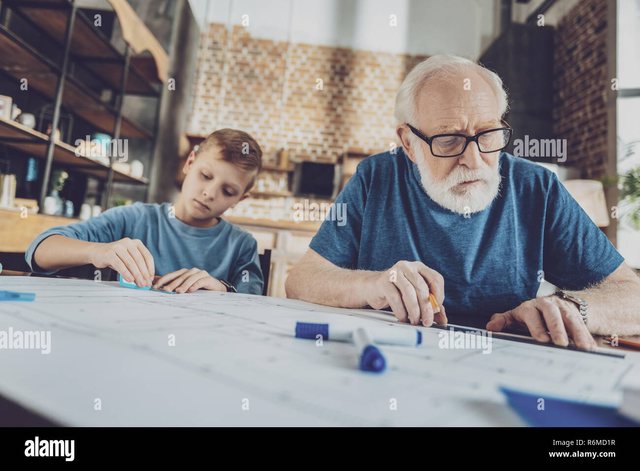 Concentrated pensioner drawing straight line Stock Photo - Alamy