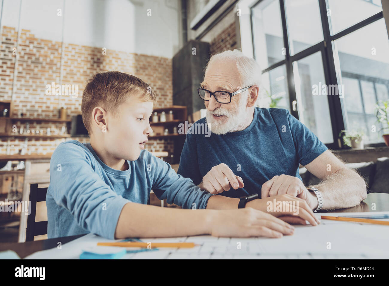 Positive delighted granddad talking to his grandson Stock Photo - Alamy