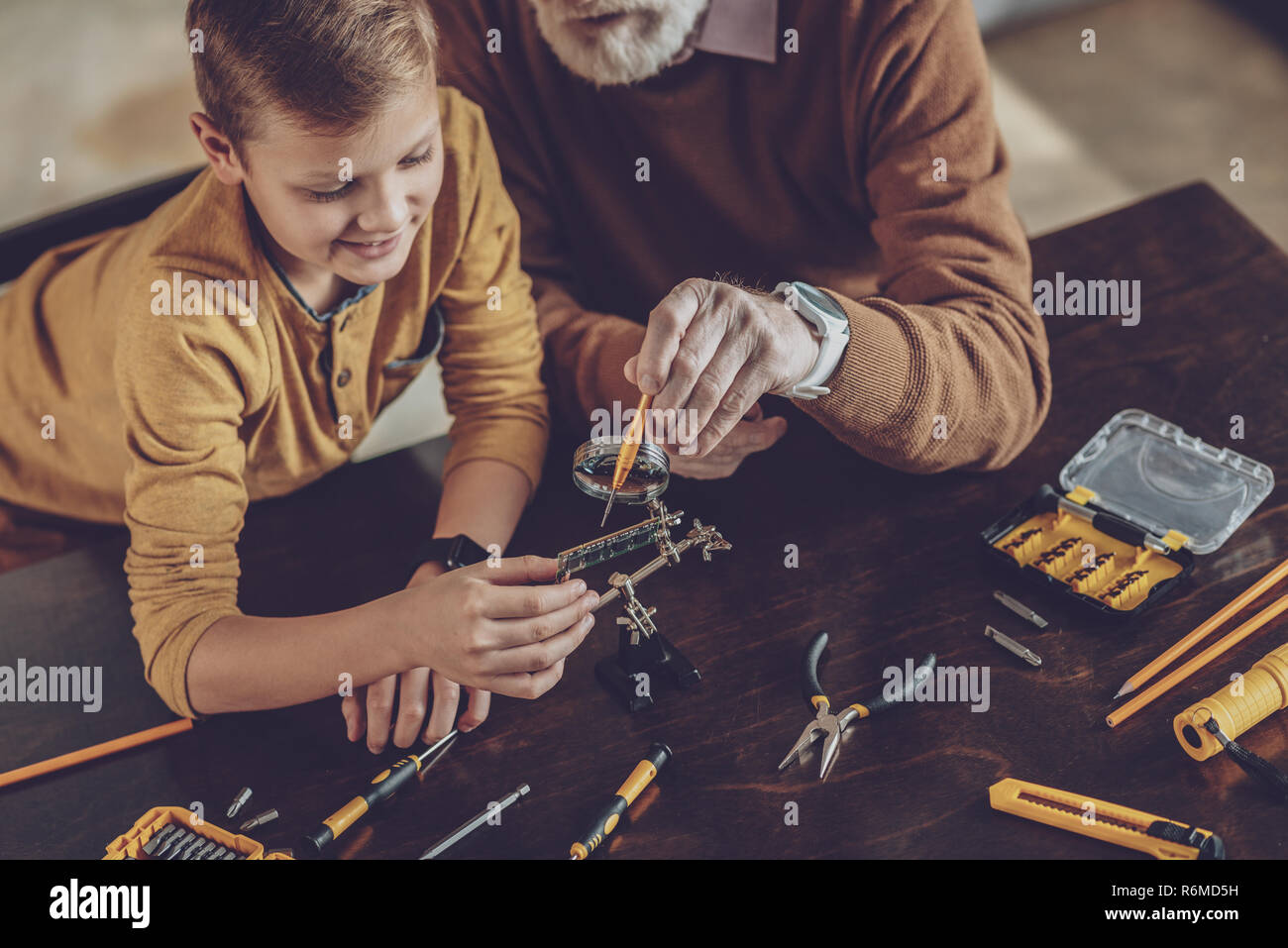 Top view picture of delighted boy that looking at chip Stock Photo - Alamy