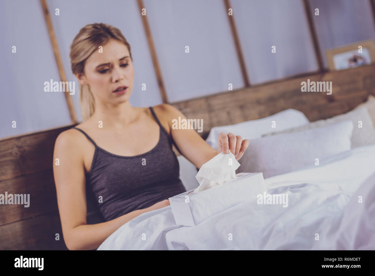 Sick young woman taking tissue from the box Stock Photo - Alamy