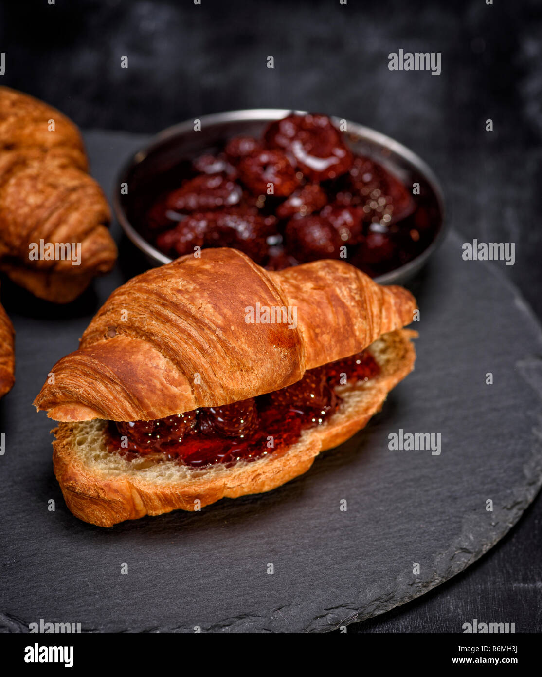 baked croissant with strawberry jam on a black background Stock Photo ...